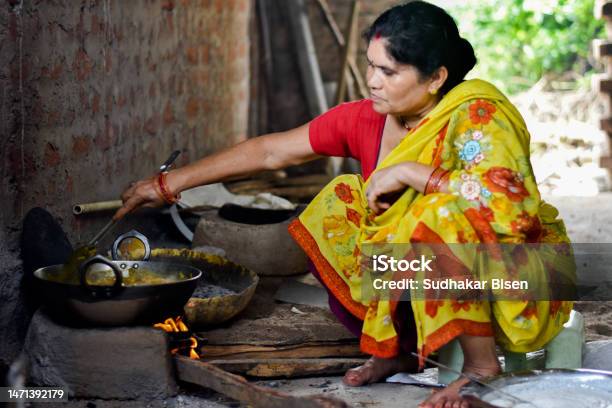 Indian Woman Cooking Food In Traditional Kitchen Using Firewood In