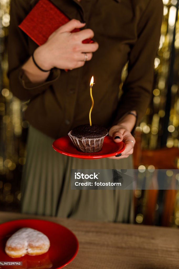 Young Woman Making A Wish Before Blowing Out Her Birthday Candle On A