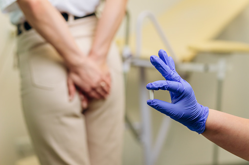 Woman At A Proctologists Appointment The Doctor Holds A Rectal
