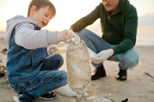 Relawan Keluarga Membersihkan Pantai Dengan Mengumpulkan Sampah Plastik