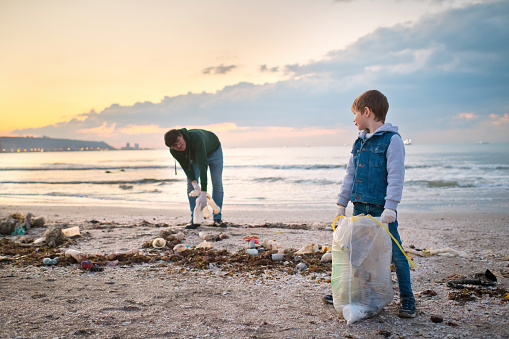 Relawan Keluarga Membersihkan Pantai Dengan Mengumpulkan Sampah Plastik