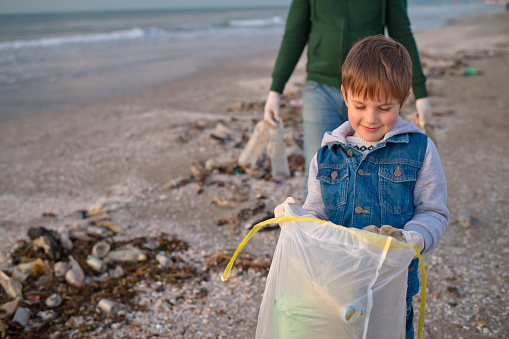 Relawan Keluarga Membersihkan Pantai Dengan Mengumpulkan Sampah Plastik
