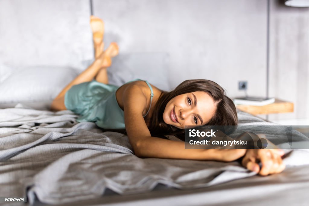 Photo Of Young Happy Woman In Pajama Stretching Her Arms And Smiling