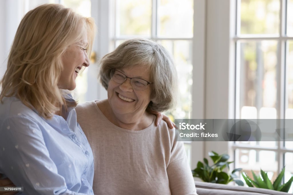 Caring Middleaged Woman Hugging Her Senior Greyhaired Mother Stock