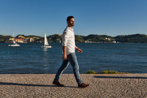 Free Stock Photo of Man Walking Down Sidewalk Along River | Download ...