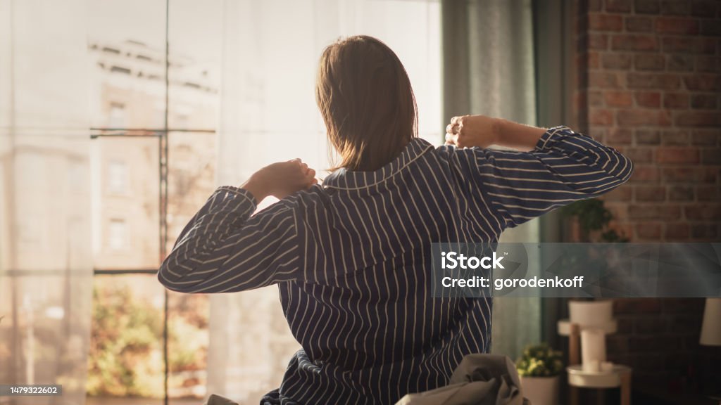Beautiful Caucasian Woman Waking Up In The Morning Stretches Gets Out