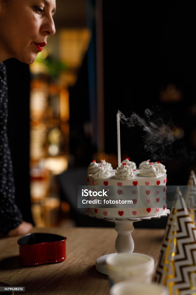 Woman Making A Wish Before Blowing Out The Birthday Candle In A Cake