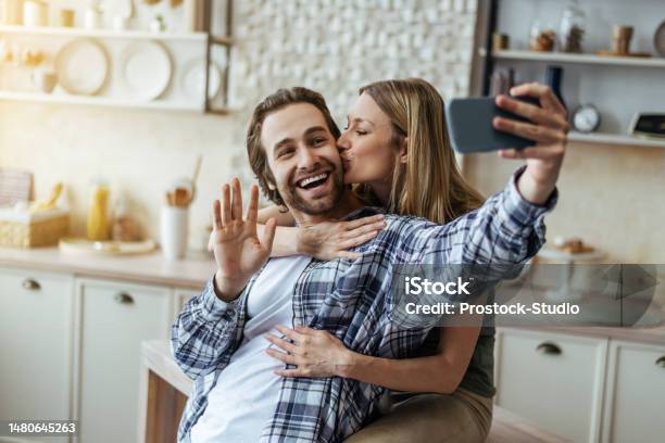 Happy Caucasian Millennial Husband With Stubble And Blonde Wife Hugs