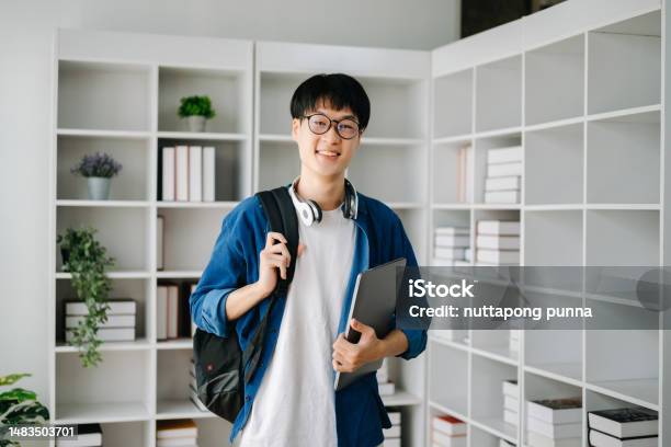 Siswa Lakilaki Mencatat Dari Buku Di Perpustakaan Orang Asia Muda Duduk ... Siswa Lakilaki Mencatat Dari Buku Di Perpustakaan Orang Asia Muda Duduk ...
