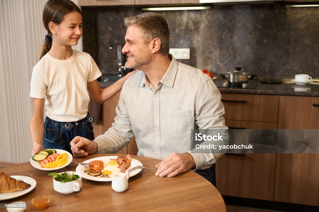Kleine Tochter Und Glücklicher Vater Frühstücken Gemeinsam In Der Küche