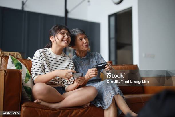 Seorang Nenek Asia Yang Ceria Dan Cucunya Sedang Duduk Di Sofa Di Ruang ... Seorang Nenek Asia Yang Ceria Dan Cucunya Sedang Duduk Di Sofa Di Ruang ...