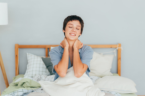 Si Rambut Cokelat Muda Yang Menarik Duduk Di Tempat Tidur Di Pagi Hari