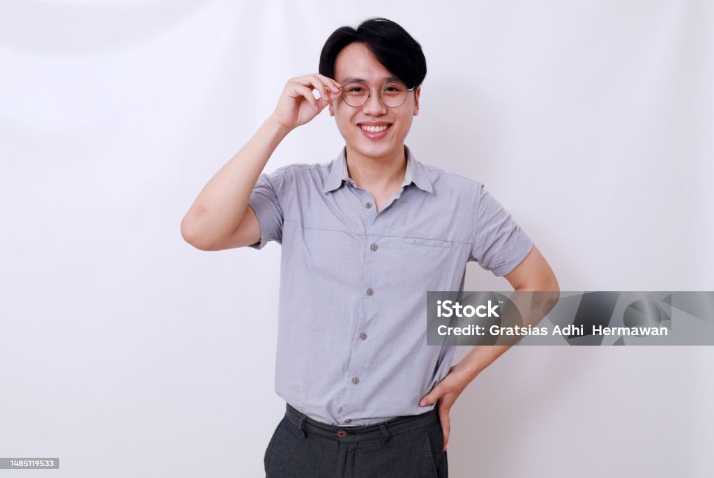 Handsome Young Asian Man Standing While Holding His Eyeglass Frames