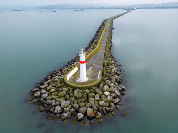 Free Stock Photo of Lighthouse at the end of a long curved stone ...