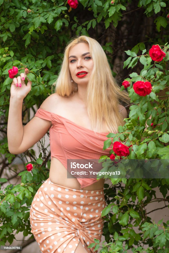 Beautiful Woman With Long Blonde Hair And Red Lips Wearing Pink Clothes