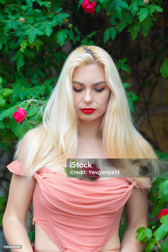 Beautiful Woman With Long Blonde Hair And Red Lips Wearing Pink Clothes