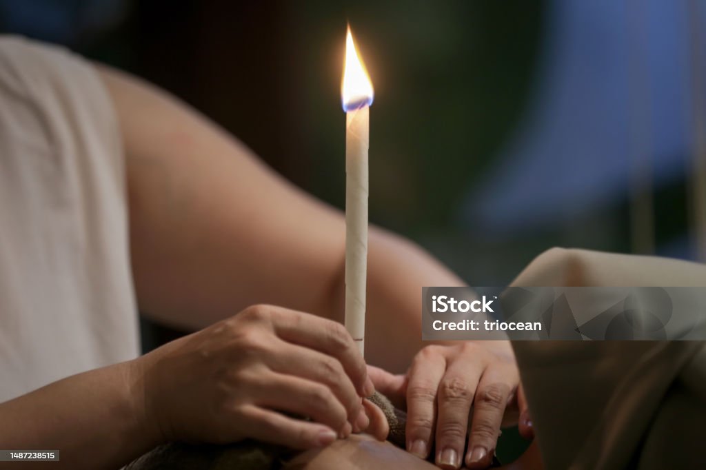 Woman Receiving Ear Candle Treatment At Spa Ear Coning Or