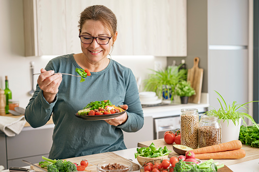 Smiling Mature Woman Eating Healthy Plantbased Meal Stock Photo ... Smiling Mature Woman Eating Healthy Plantbased Meal Stock Photo ...