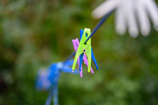 Clothespins Hanging On A Clothesline On A Blurred Green Background