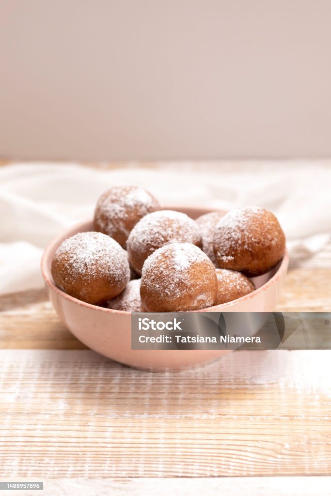 Paczki หรือ Zeppole ในชามสีชมพูพร้อมน้ําตาลผงบนโต๊ะไม้ Fat Thursday ... Paczki หรือ Zeppole ในชามสีชมพูพร้อมน้ําตาลผงบนโต๊ะไม้ Fat Thursday ...