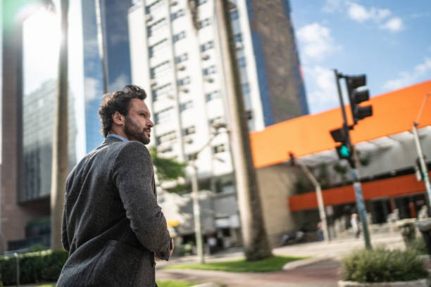 Free Stock Photo of Man Walking Down Street Next to Tall Building ...