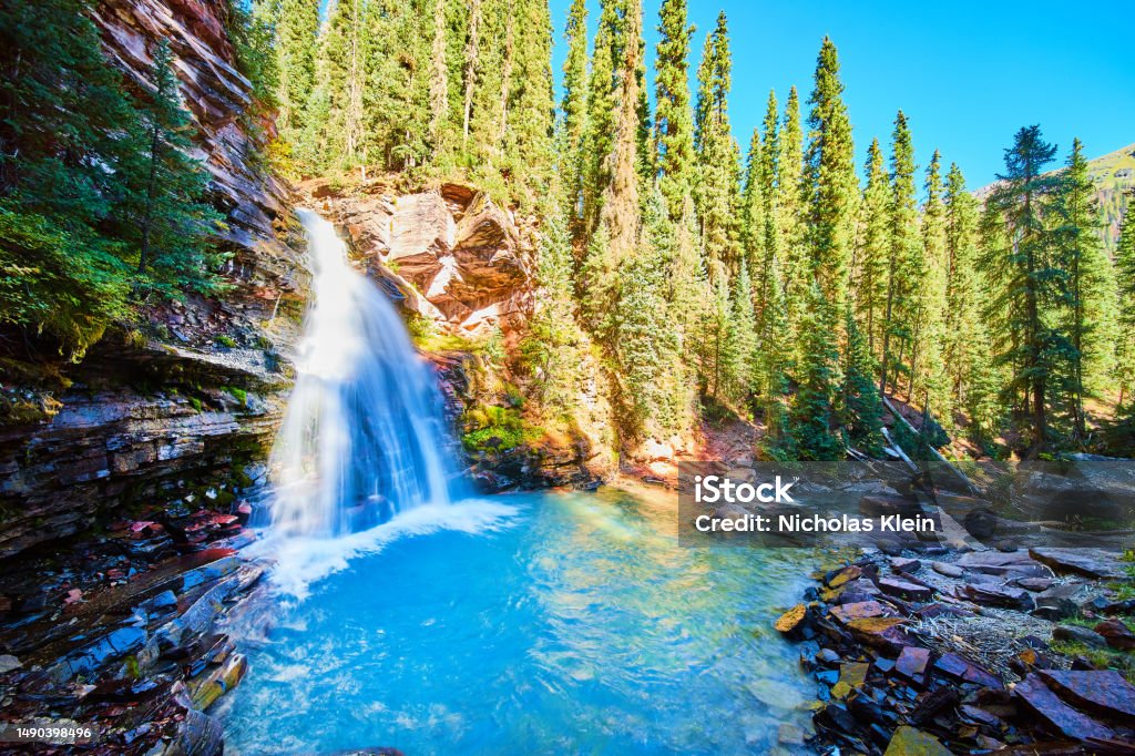Air Terjun Biru Yang Megah Dan Semarak Di Atas Ngarai Ke Ngarai Dengan Hutan Pohon Pinus Foto