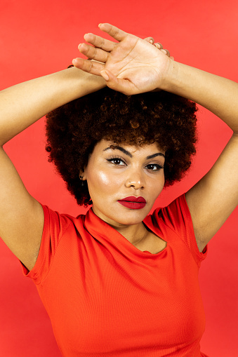 A Darkskinned Girl With Afro Hair Poses On A Red Background The Girl