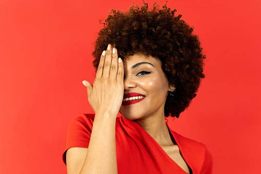A Darkskinned Smiling Girl With Curly Afro Hair Posing On A Red