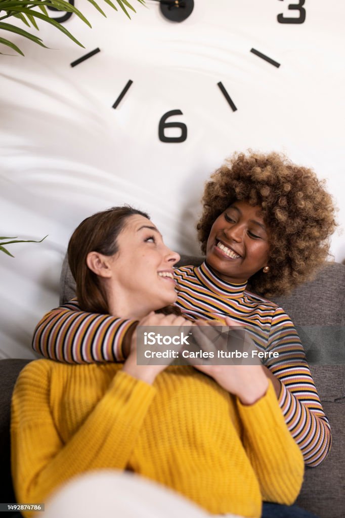 Multiracial Lesbian Couple Hugging And Laughing And Relaxing In A