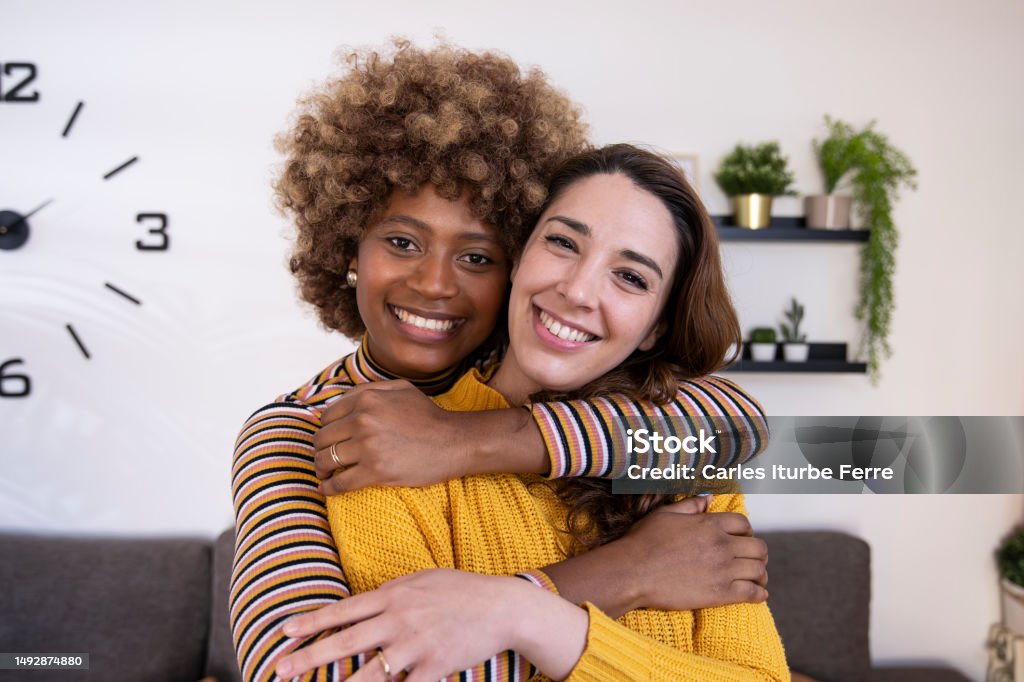 Beautiful And Cheerful Multiracial Lesbian Couple Hugging And Looking
