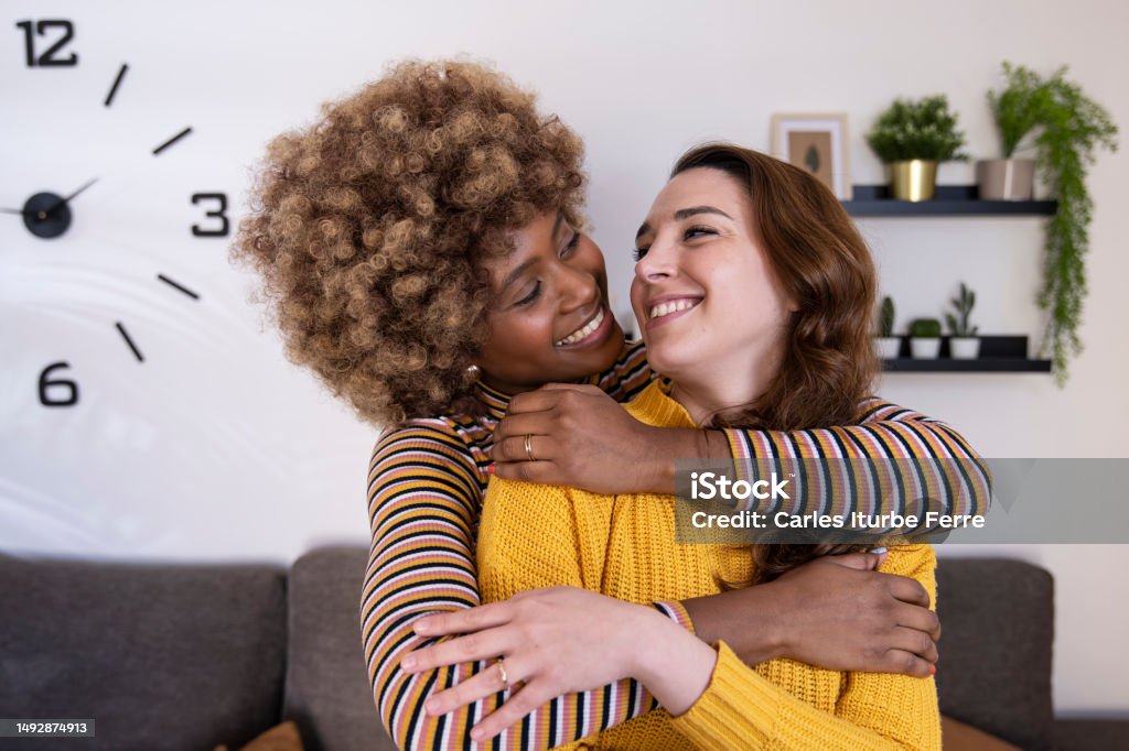 Beautiful And Cheerful Multiracial Lesbian Couple Hugging And Looking