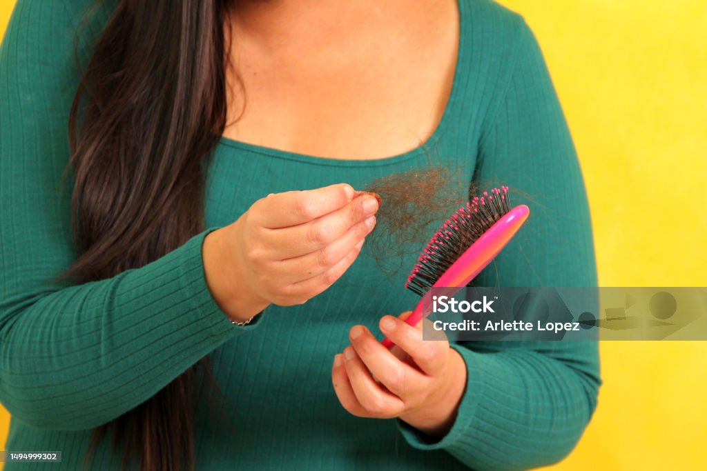 Latin Adult Woman With Very Long Straight Hair Suffers From Hair Loss Looking At The Brush How