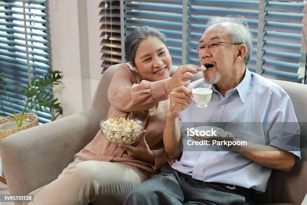 Pria Dan Wanita Senior Asia Yang Tersenyum Bahagia Duduk Di Sofa Dan ... Pria Dan Wanita Senior Asia Yang Tersenyum Bahagia Duduk Di Sofa Dan ...