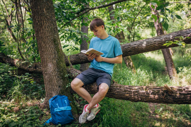 Free Stock Photo of Man kneeling and reading a book in nature ...
