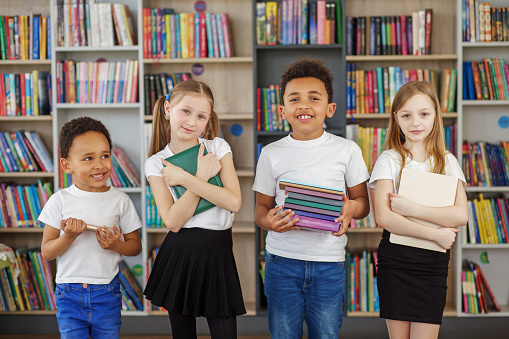 Empat Anak Memegang Tumpukan Buku Di Perpustakaan Teman Sekelas ... Empat Anak Memegang Tumpukan Buku Di Perpustakaan Teman Sekelas ...