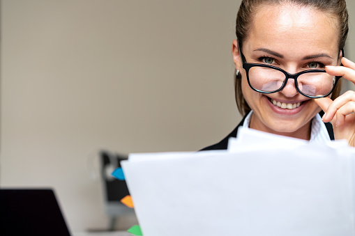 Portrait Of Joyful Businesswoman Wearing Glasses Smiling While Doing