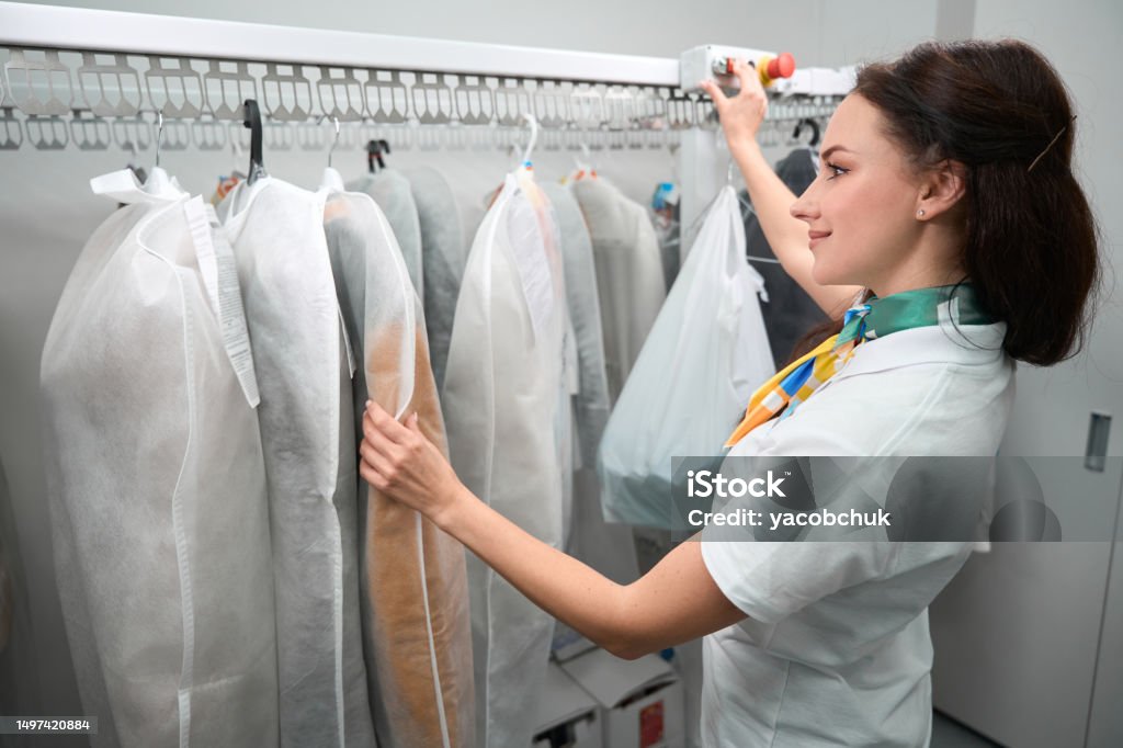 Smiling Laundry Office Worker Pushing Button To Rotate Rack With