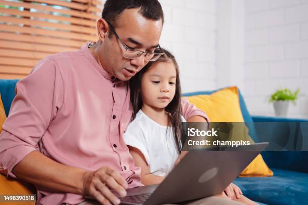 Putri Asia Kecil Yang Lucu Dengan Ayah Bekerja Di Laptop Di Rumah Ayah