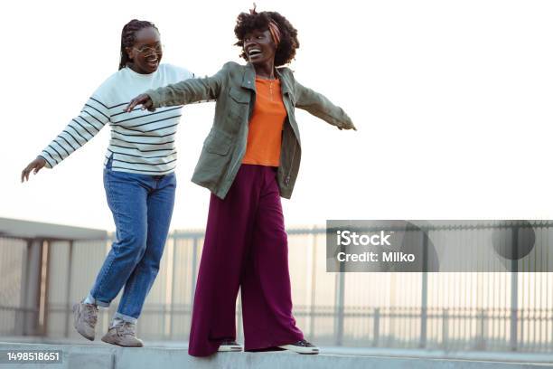 Wanita Muda Afrikaamerika Yang Ceria Memegang Keseimbangan Di Dinding ... Wanita Muda Afrikaamerika Yang Ceria Memegang Keseimbangan Di Dinding ...