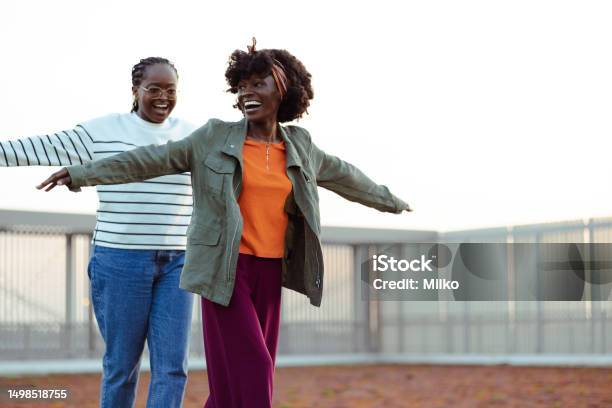 Wanita Muda Afrikaamerika Yang Ceria Memegang Keseimbangan Di Dinding ... Wanita Muda Afrikaamerika Yang Ceria Memegang Keseimbangan Di Dinding ...
