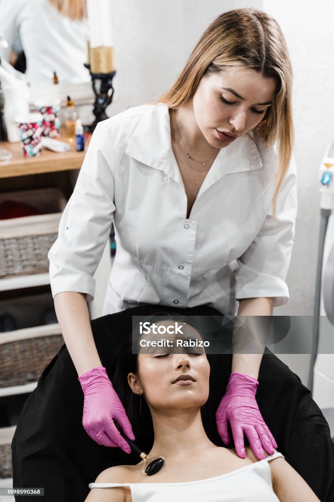 Process Of Face Massage With Black Stone Roller Cosmetologist Using