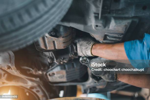 Di Bengkel Seorang Mekanik Memperbaiki Suspensi Mobil Yang Ditinggikan