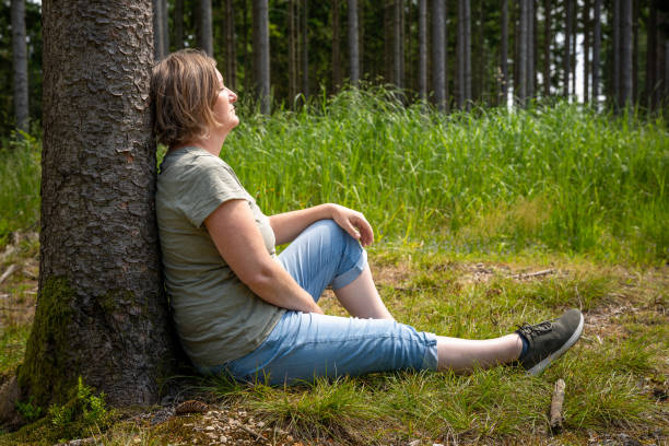 Free picture: Blonde woman relaxing underneath tree trunk in casual shirt