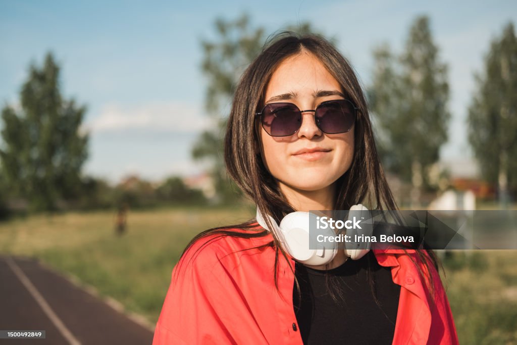 Portrait Of Cheerful Girl Wearing Red Shirt And Sunglasses Standing On