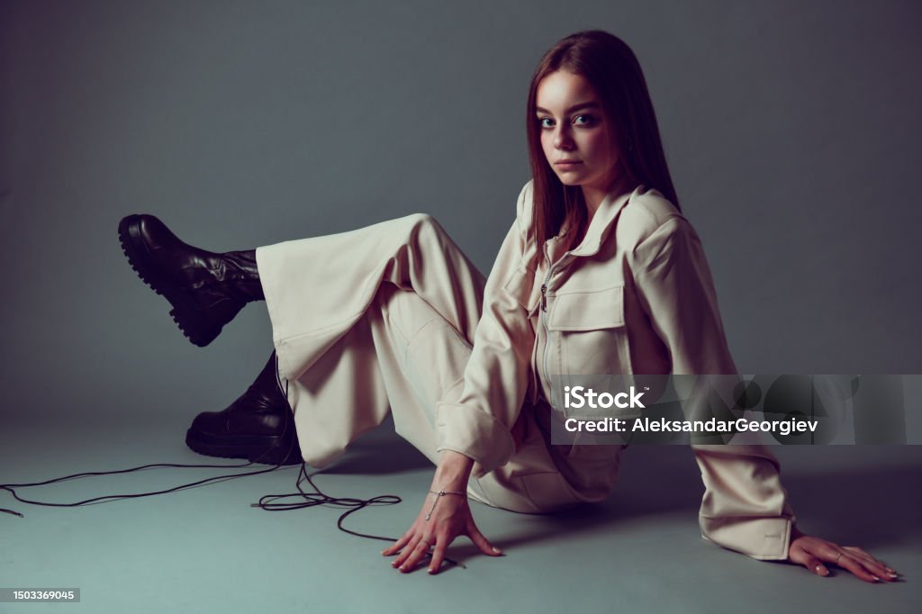 Female Model In Cream Colored Outfit Sitting Down With Legs Crossed