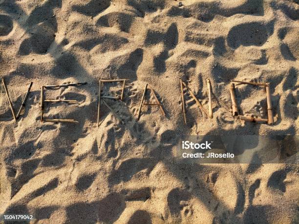 Frasa Yang Ditulis Dengan Tongkat Bambu Dalam Bahasa Spanyol Di Pasir Pantai Di Kaki Gambar