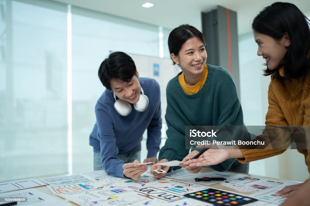 Asian Team Ux Developer And Ui Designer Brainstorming About Mobile App