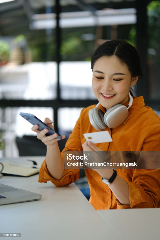 Wanita Muda Yang Gembira Memegang Kartu Kredit Dan Menggunakan Ponsel ... Wanita Muda Yang Gembira Memegang Kartu Kredit Dan Menggunakan Ponsel ...