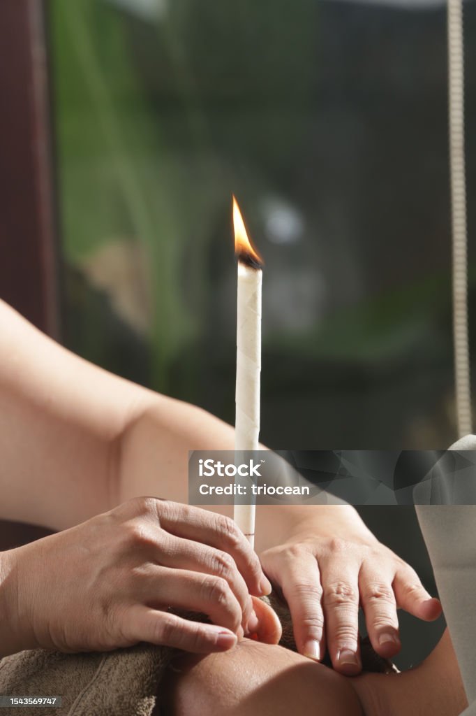 Woman Receiving Ear Candle Treatment At Spa Ear Coning Or