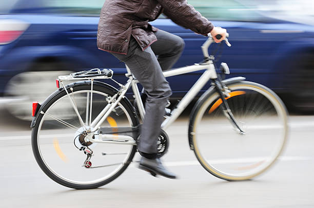 Free Stock Photo of Man Riding Bike Alongside Car on City Street ...
